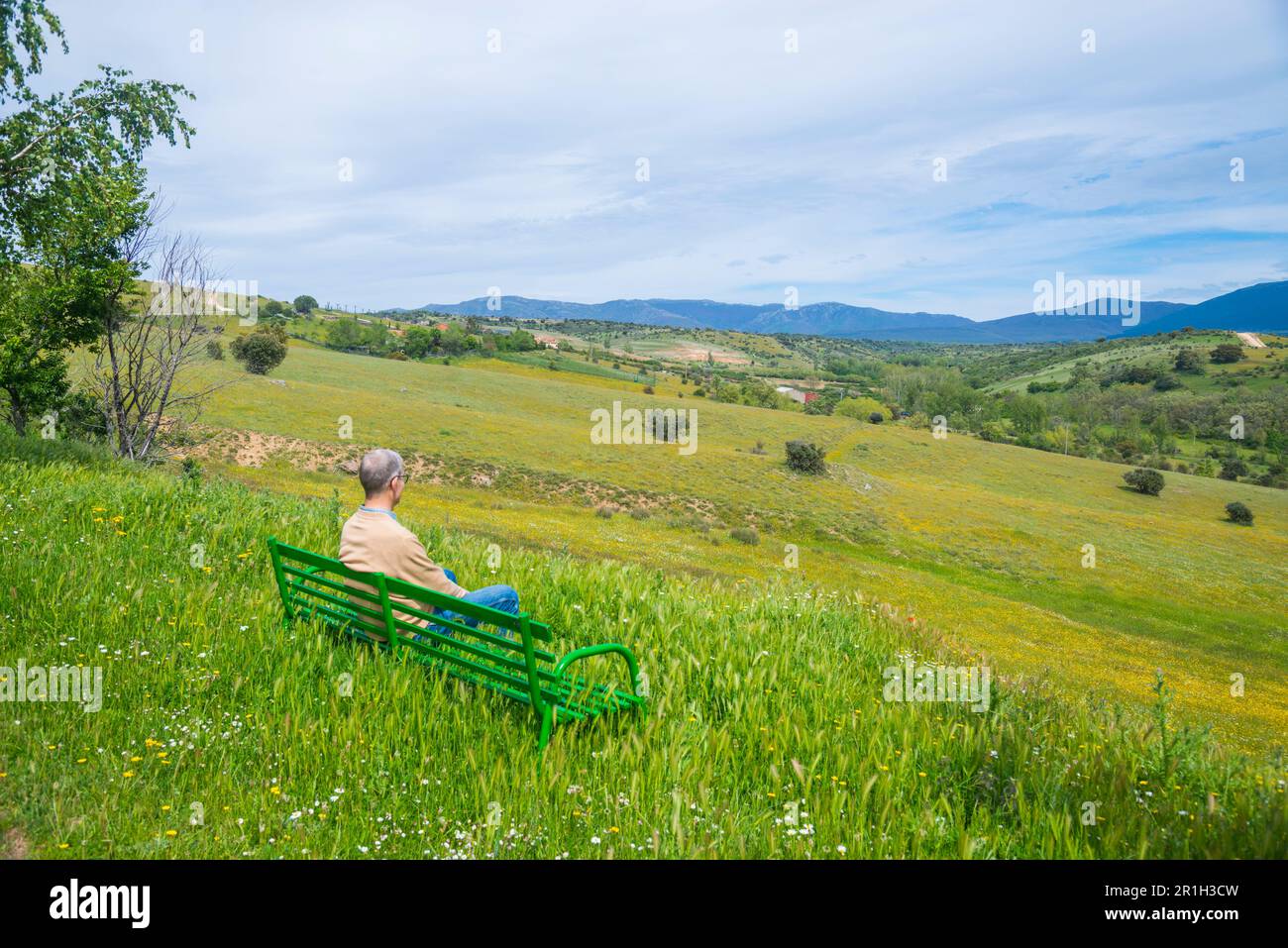 Man sitting in a bench in the countryside Stock Photo - Alamy