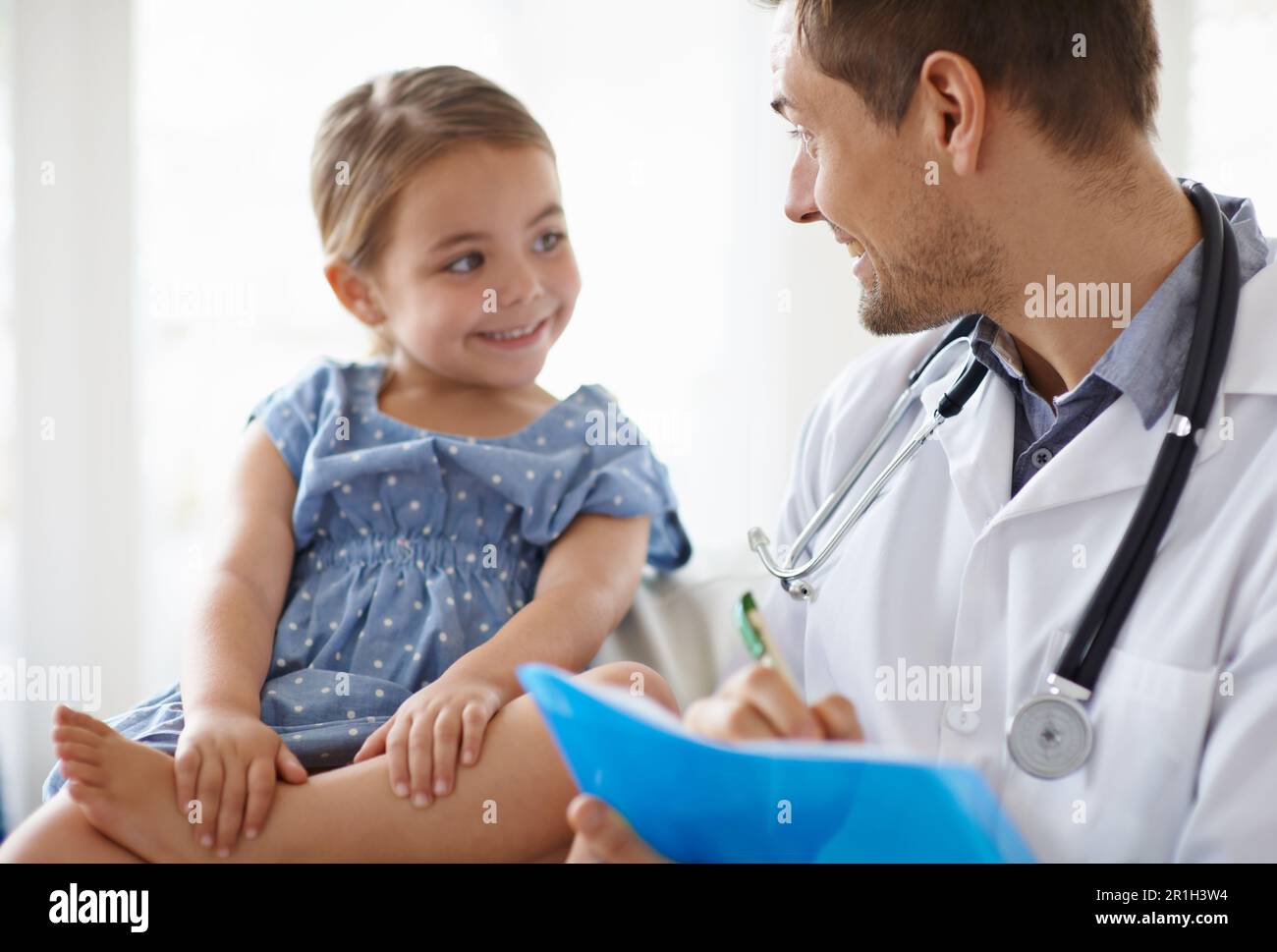 Happy, child and pediatrician writing in clinic for healthcare ...