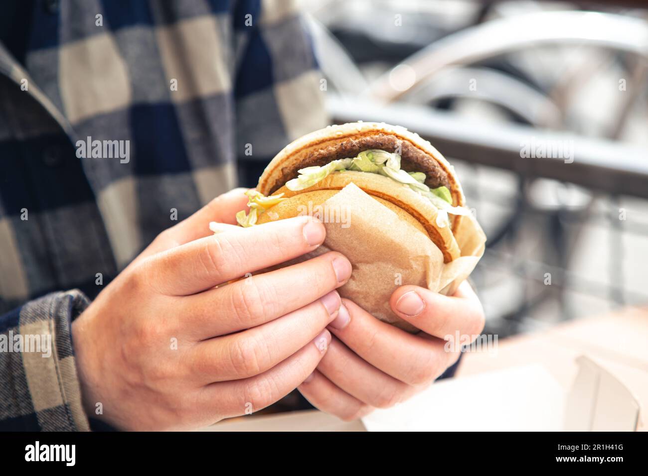 Burger in male hands close-up in a fast food cafe Stock Photo - Alamy