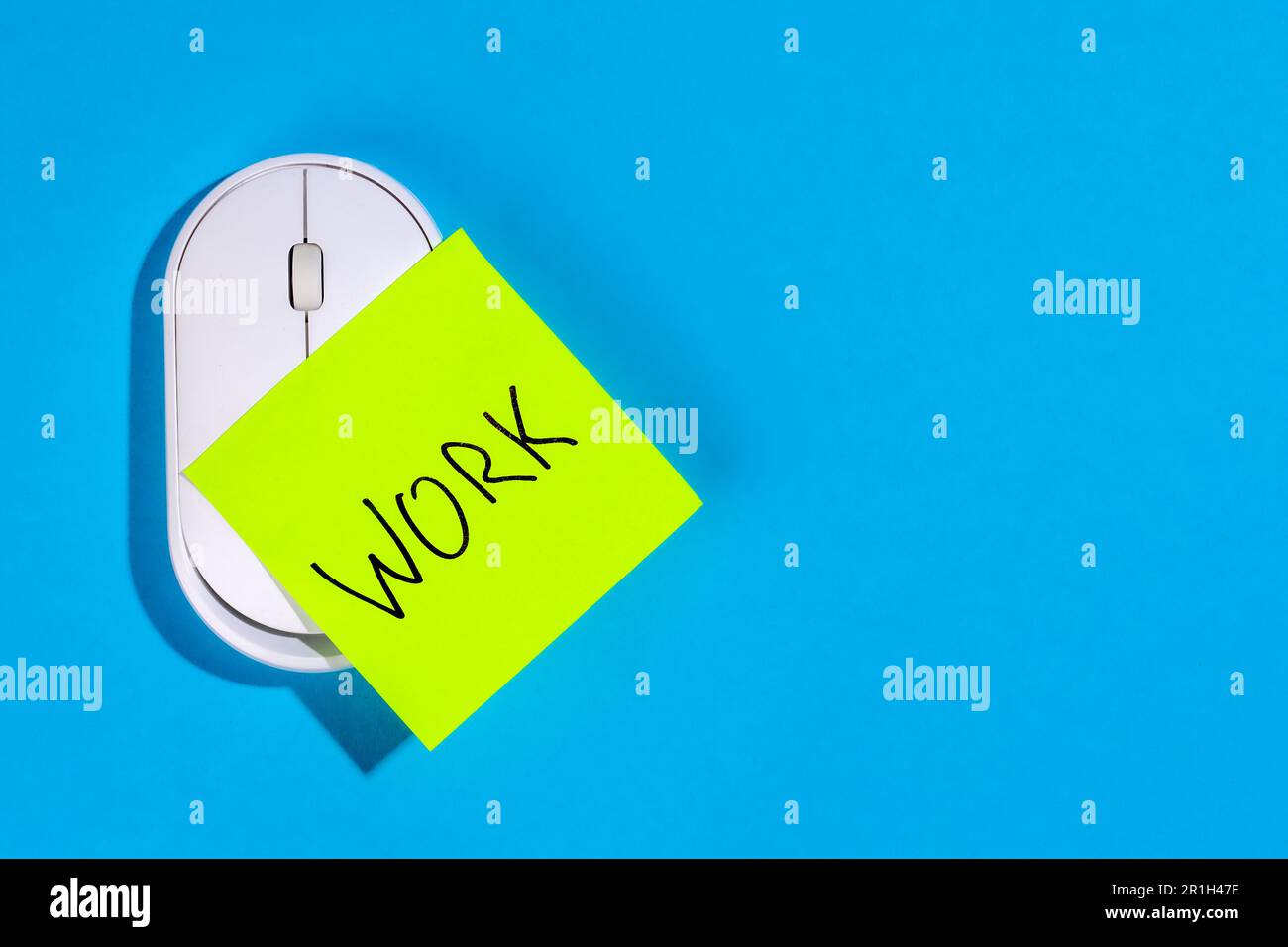 Computer mouse and reminder paper with the word work on a blue ...