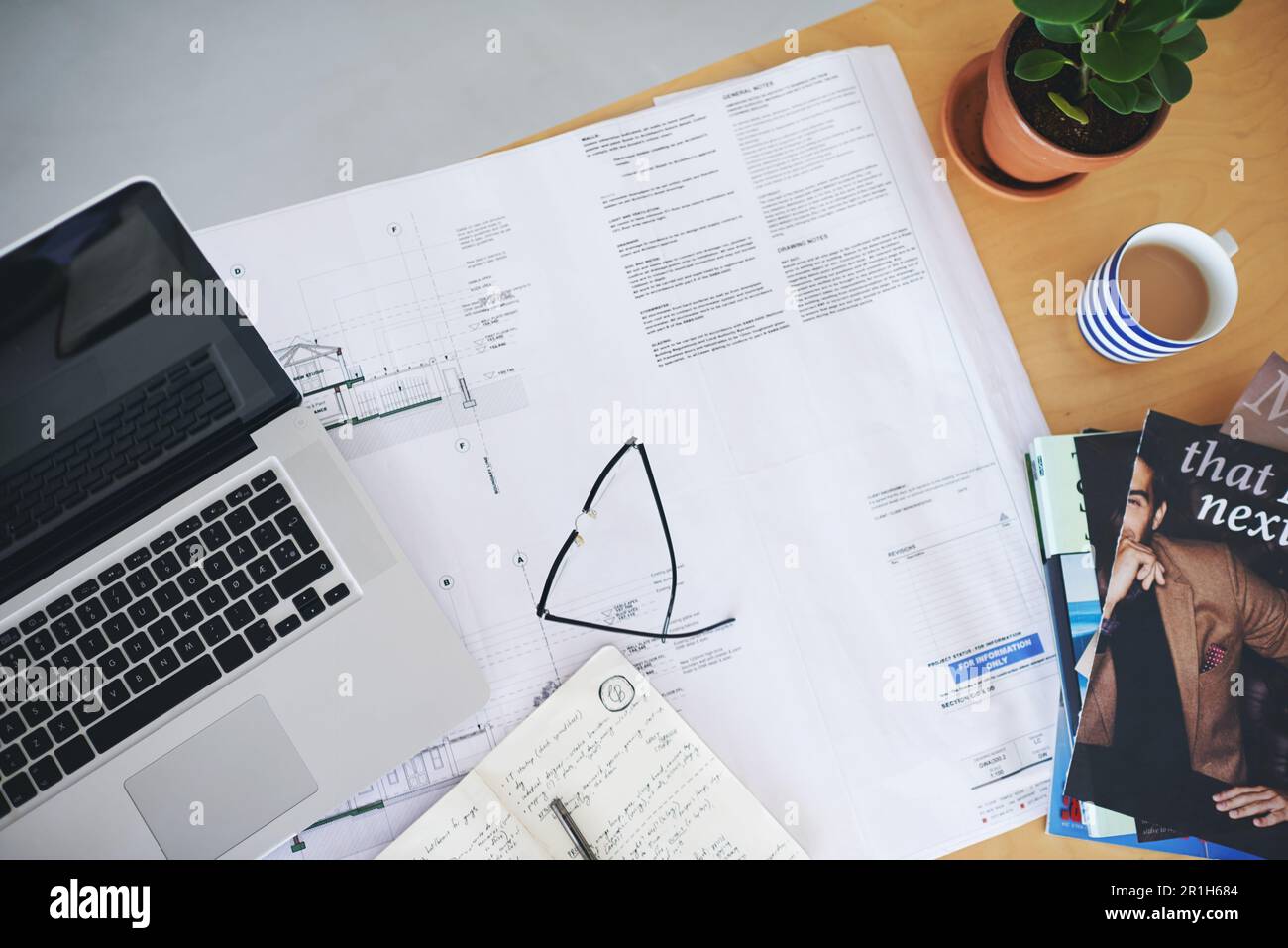 Notebook, laptop and blueprint on office desk above for architecture ...
