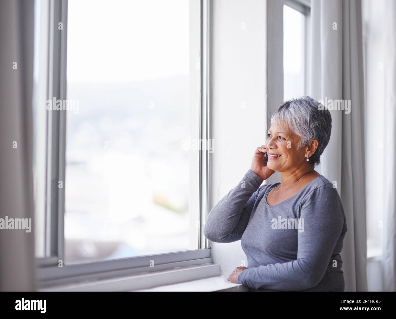 Phone call, window view and senior happy woman speaking, smile and ...