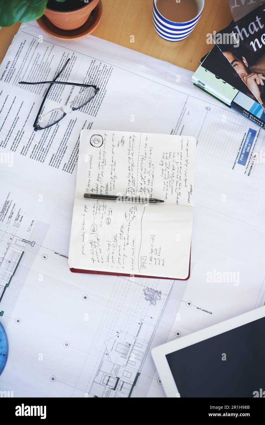 Notebook, blueprint and writing on office desk above for architecture ...