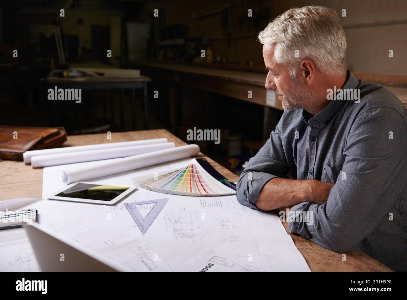 Man, senior architect and blueprint drawing in workshop, professional ...
