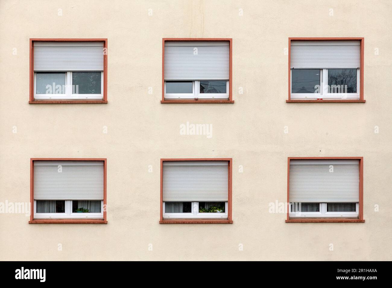 house wall with windows with partly closed plastic shutter in harmonic ...