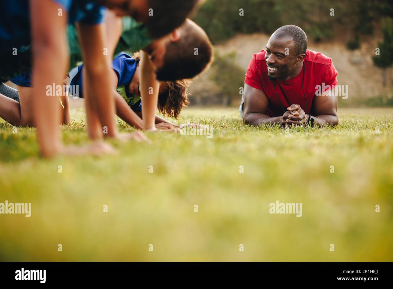 Happy school coach training a rugby team in a field. Male instructor ...