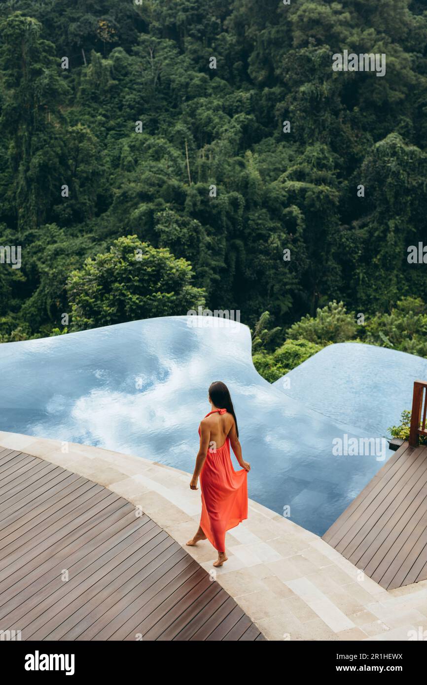 Aerial view of young female walking by swimming pool. Woman near ...