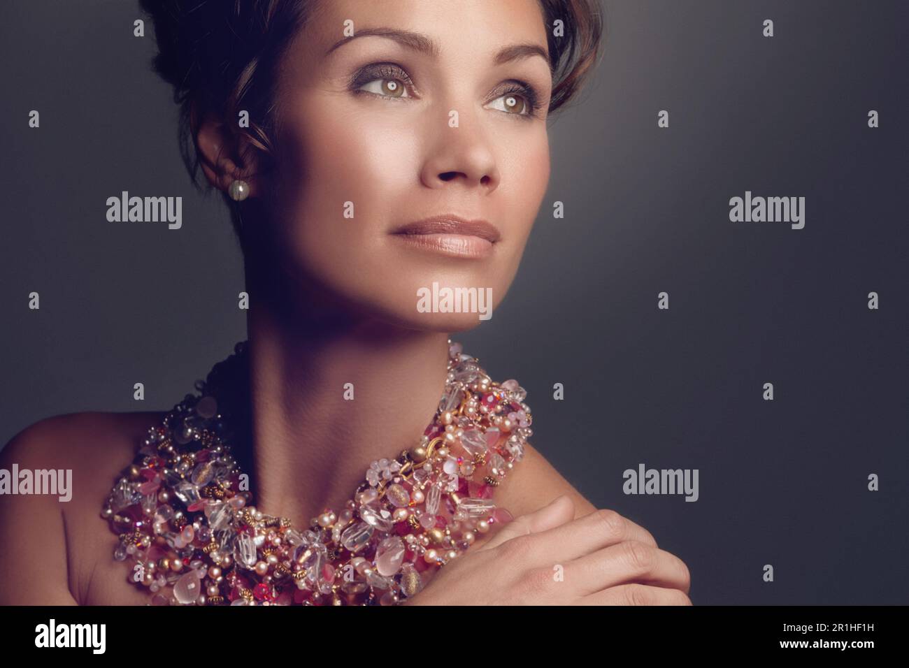 Rich woman, elegant and necklace jewelry isolated on a dark background ...