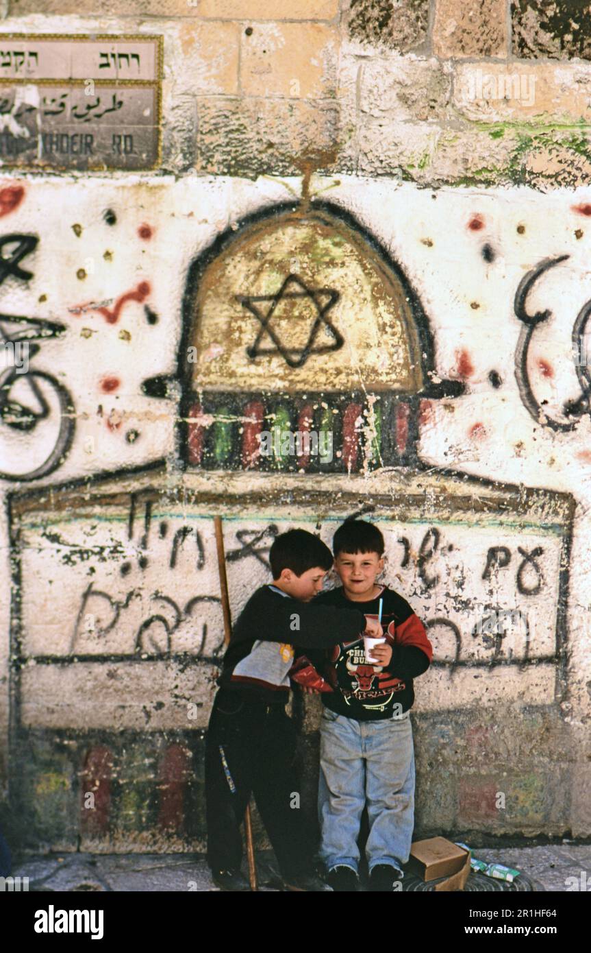 Israel: Jerusalem's Old City: two boys enjoy a snack by ancient ...