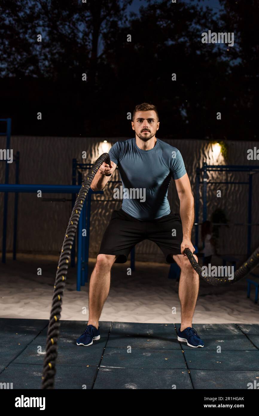 Man doing exercise with rope Stock Photo - Alamy