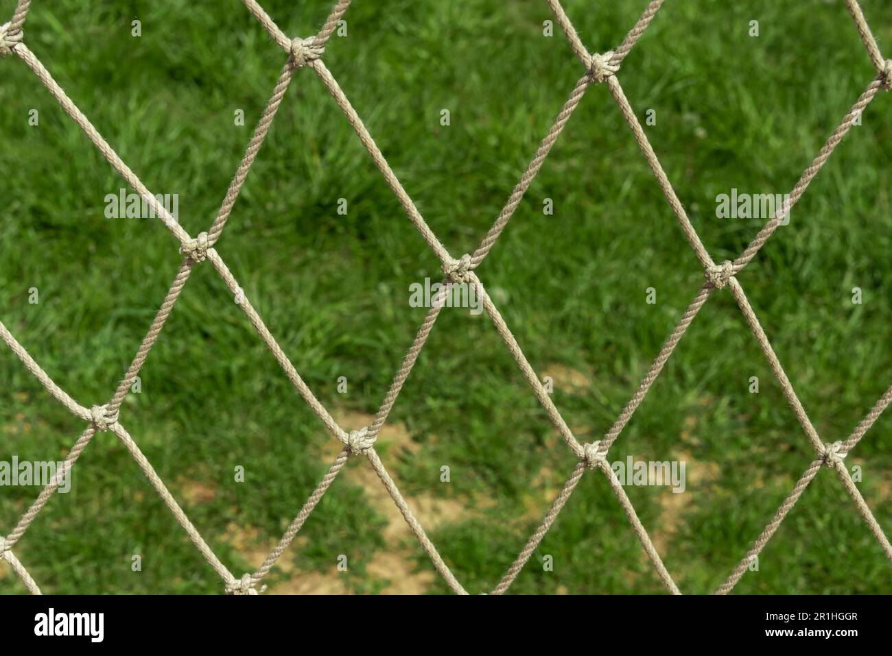 The texture of a football or tennis net on a background of green grass ...