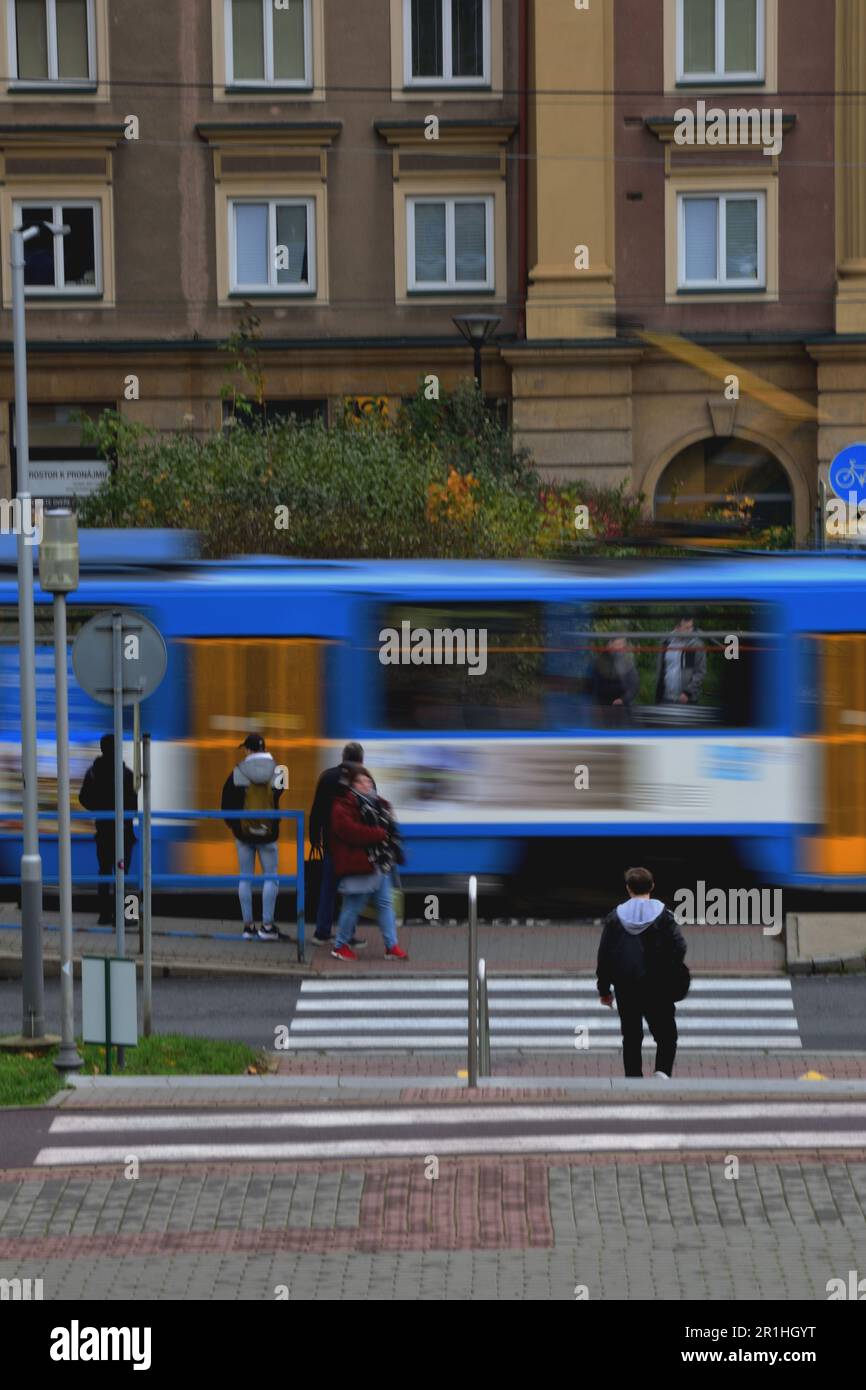 A group of people walking on a sidewalk, approaching the public bus ...