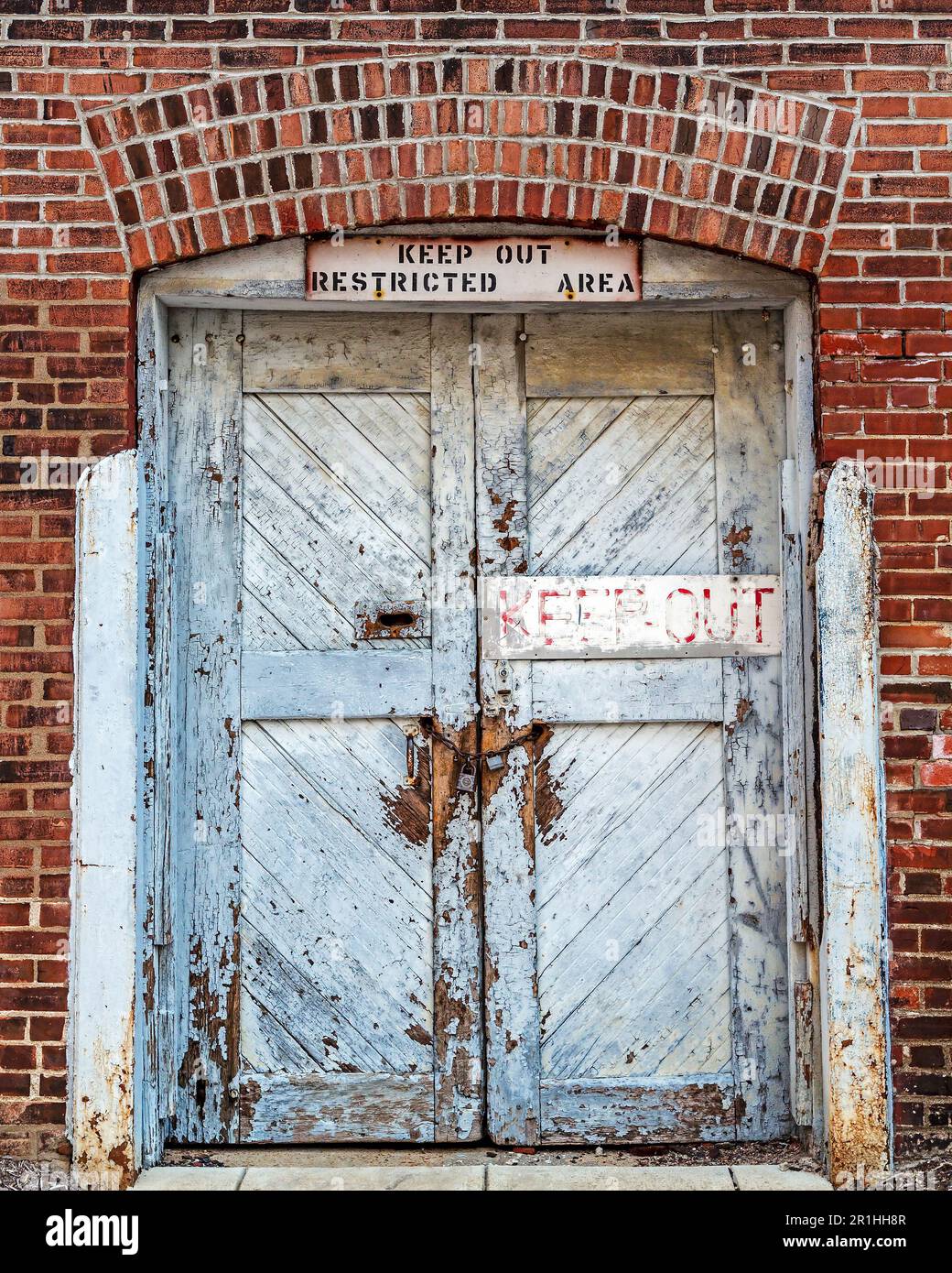 Background shot of old warehouse doors set in a brick wall with a "Keep ...