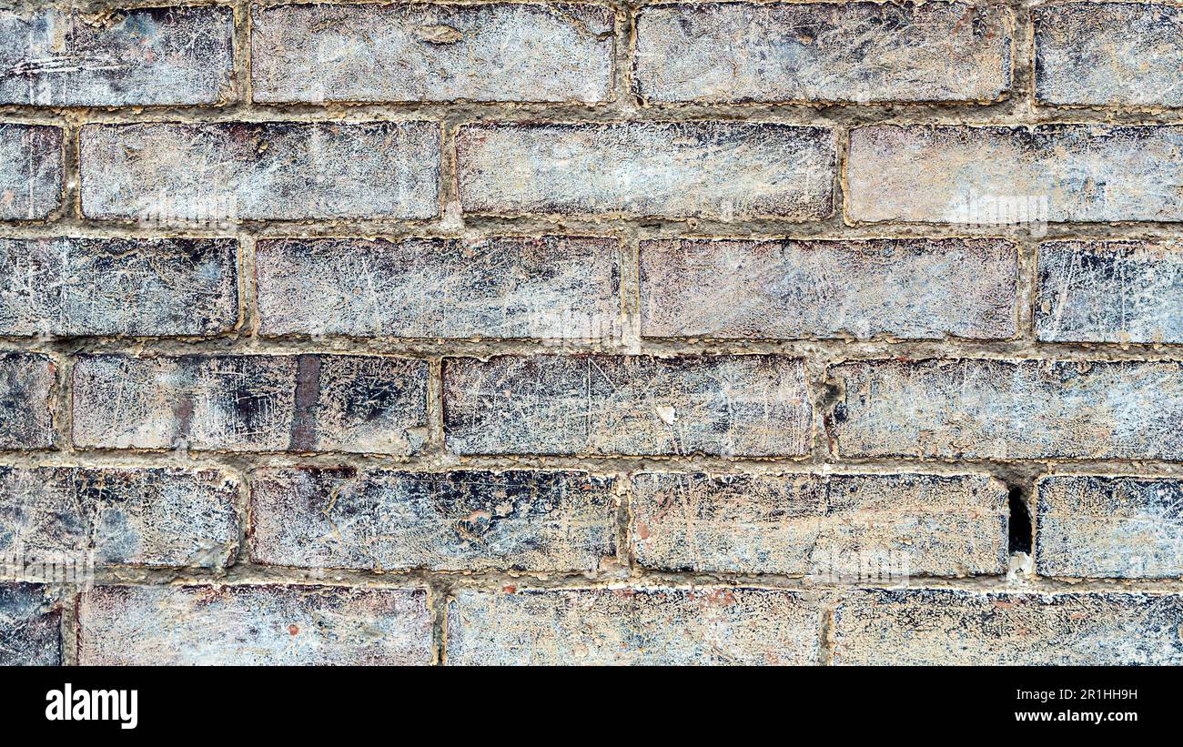 Weathered and damaged brick wall with faded white paint background ...