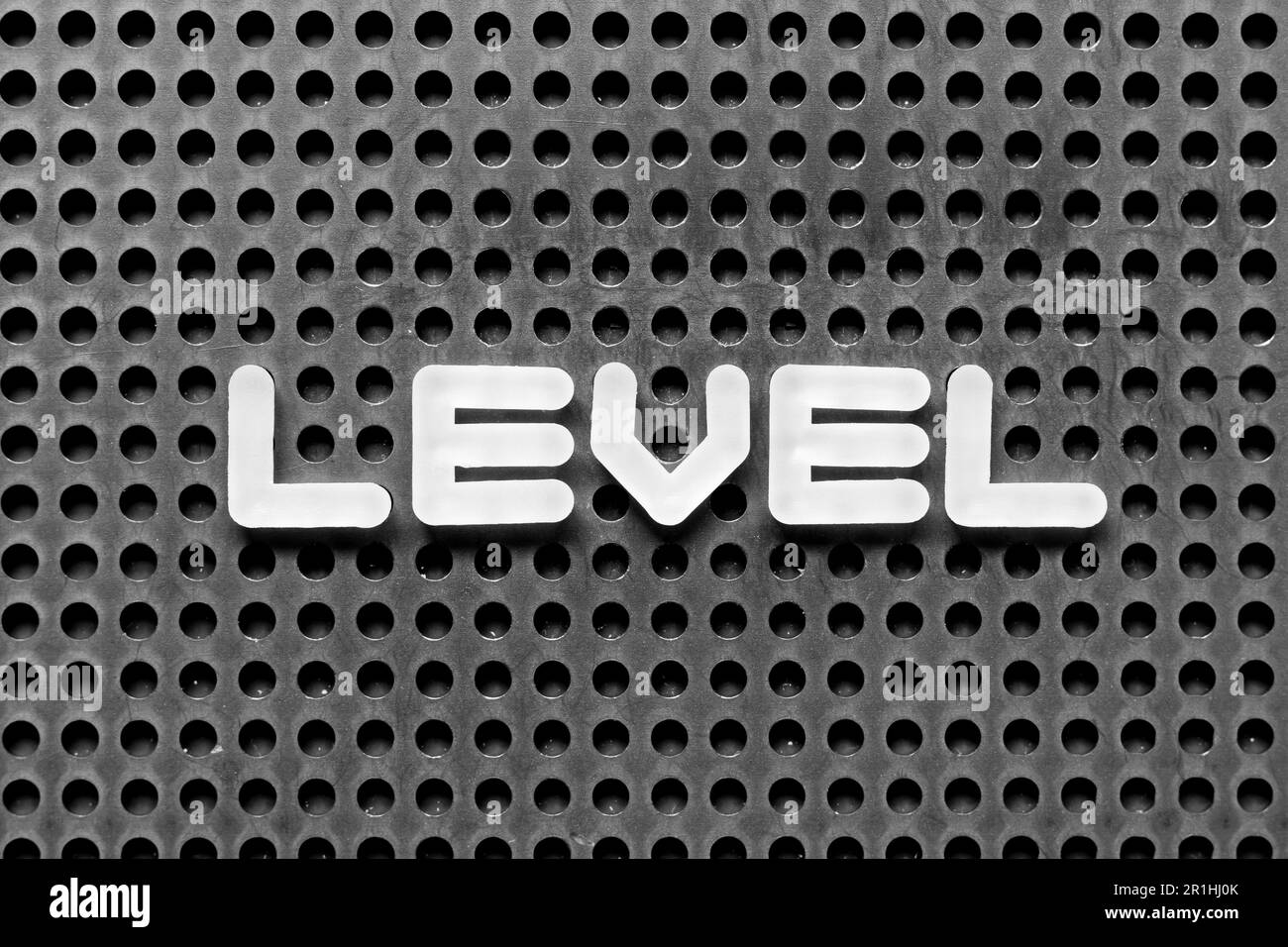 White alphabet letter in word level on black pegboard background Stock ...