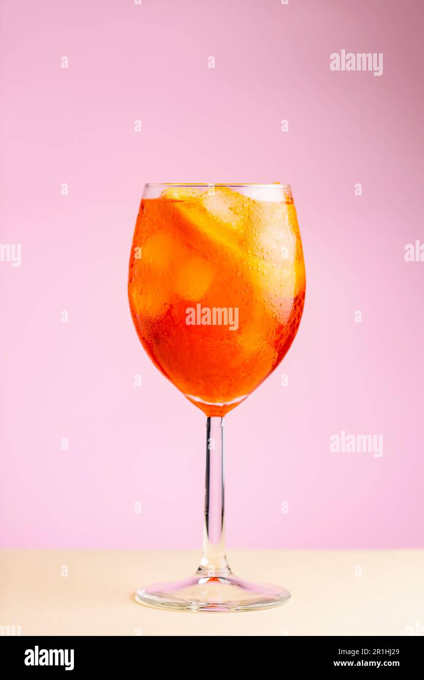 Glass of Aperol Spritz cocktail on a pink beige background. Cocktail ...