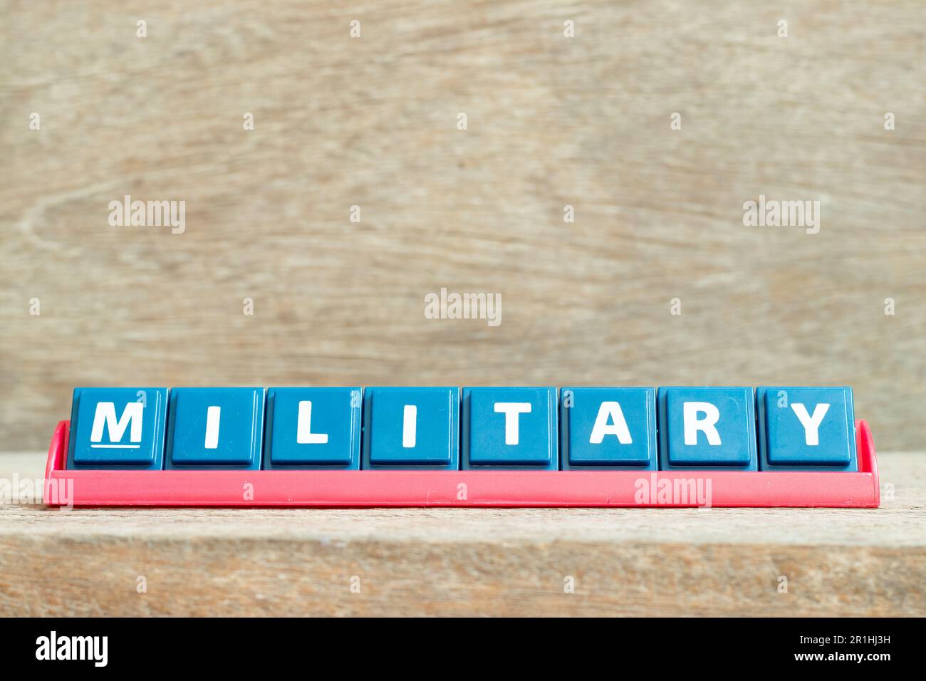 Tile alphabet letter with word military in red color rack on wood ...