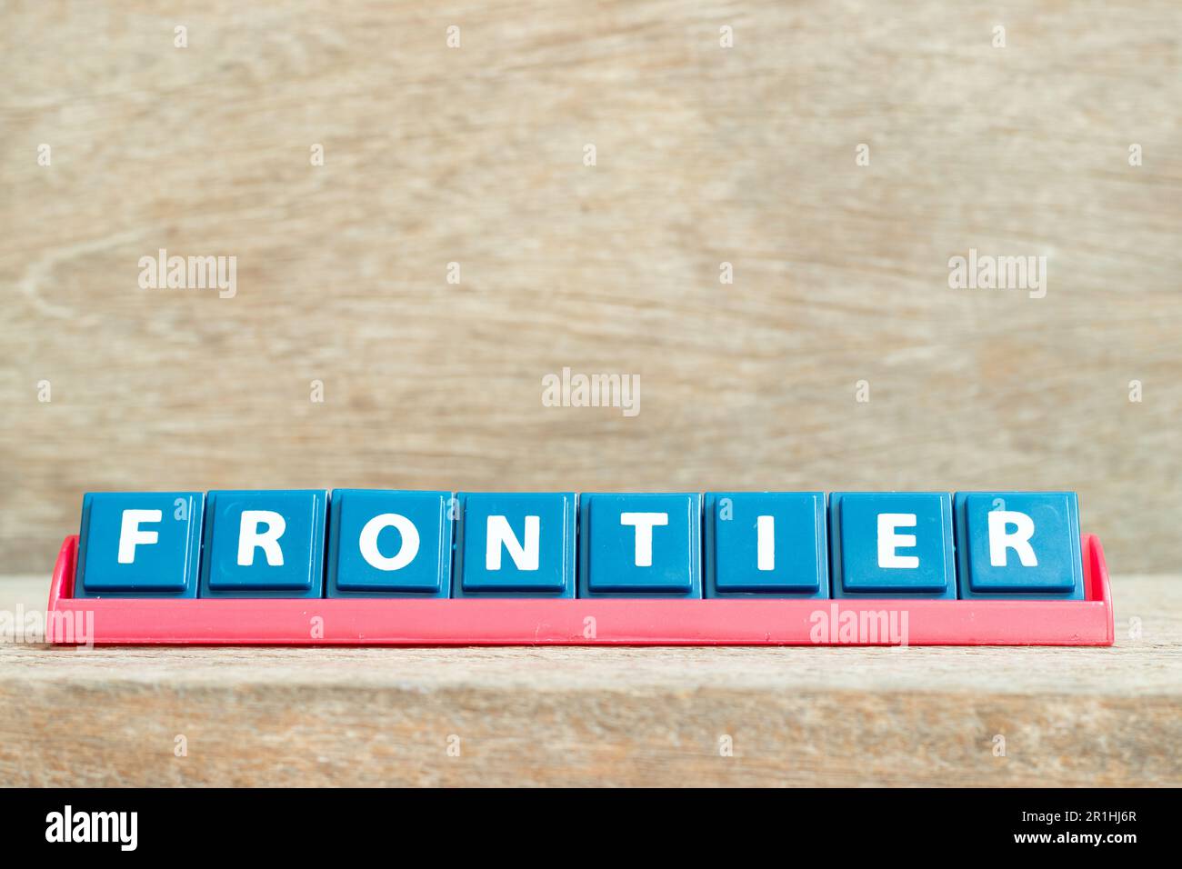Tile alphabet letter with word frontier in red color rack on wood ...