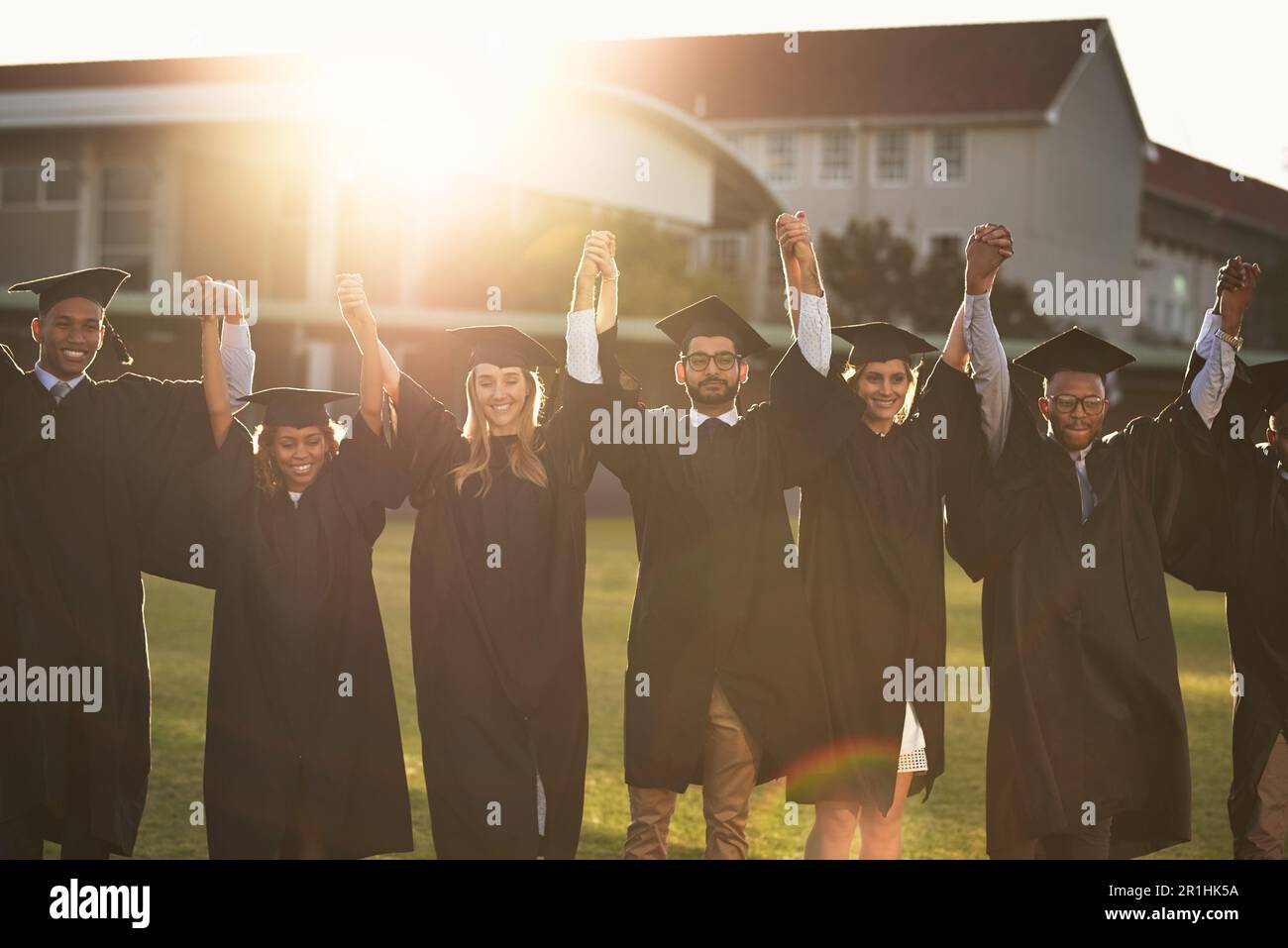 Proud of their accomplishments. a group of university students standing ...