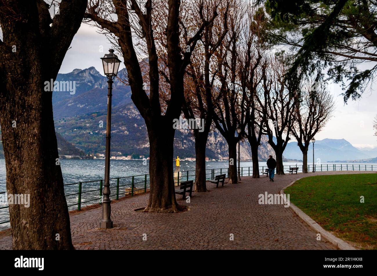 Tree lined promenade and the Golden statue of San Nicolò in Lake Como ...