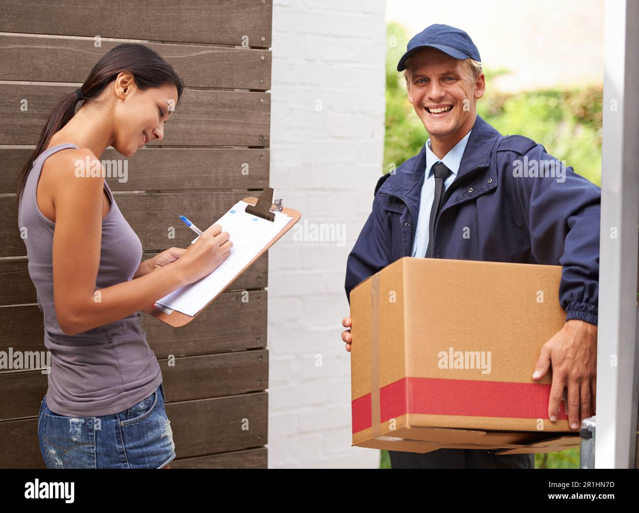 Smile, delivery and woman signing for a package or using pen from ...
