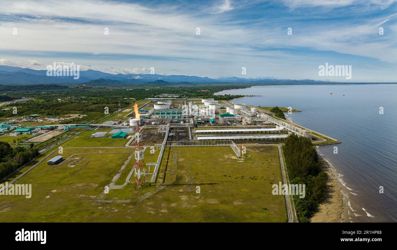 Oil refining factory with constructions and flare stacks. Ground tanks store oil and gas in an ...