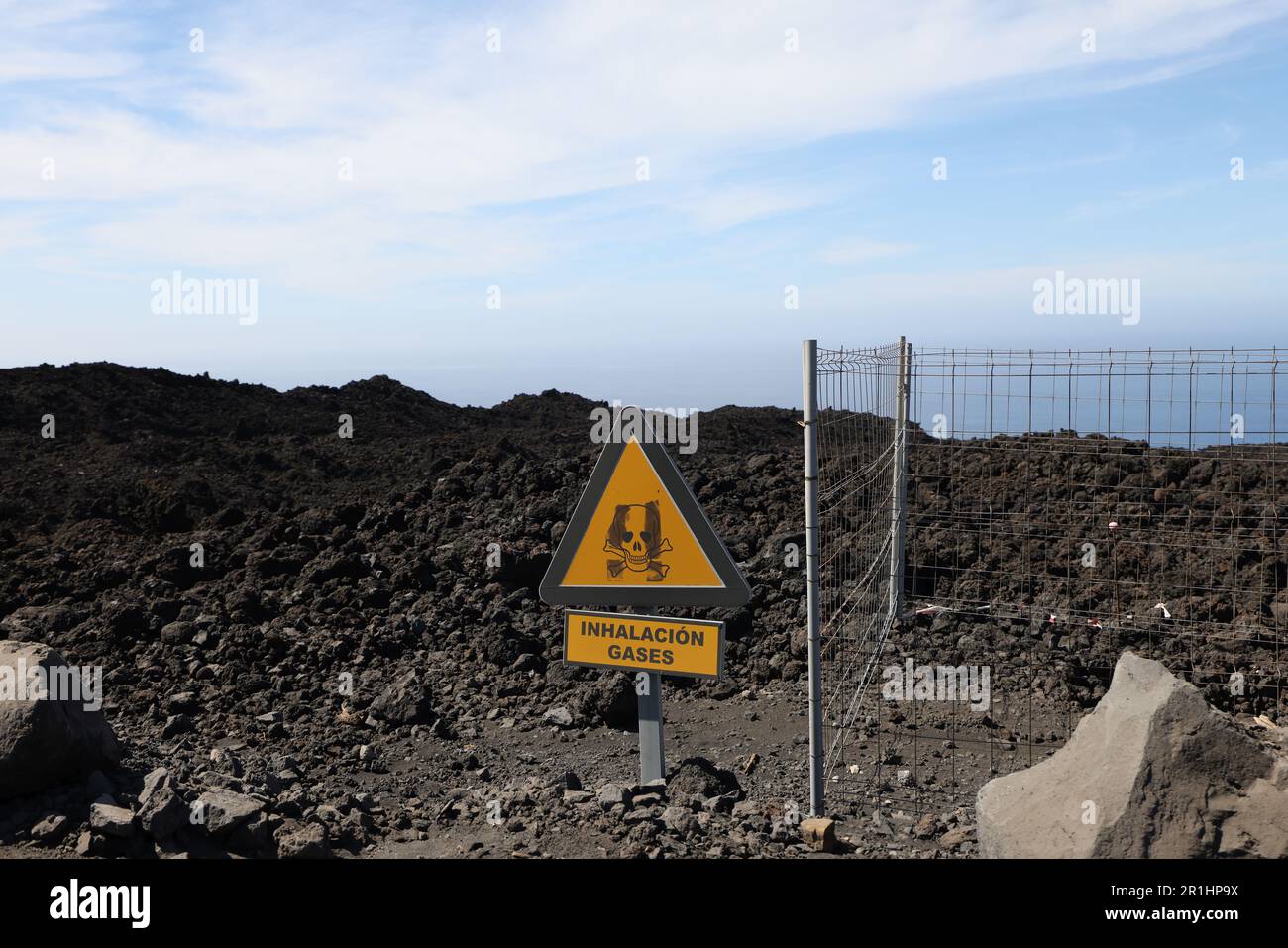 A yellow warning sign "Volcano Attention gases" in the lava on La Palma ...