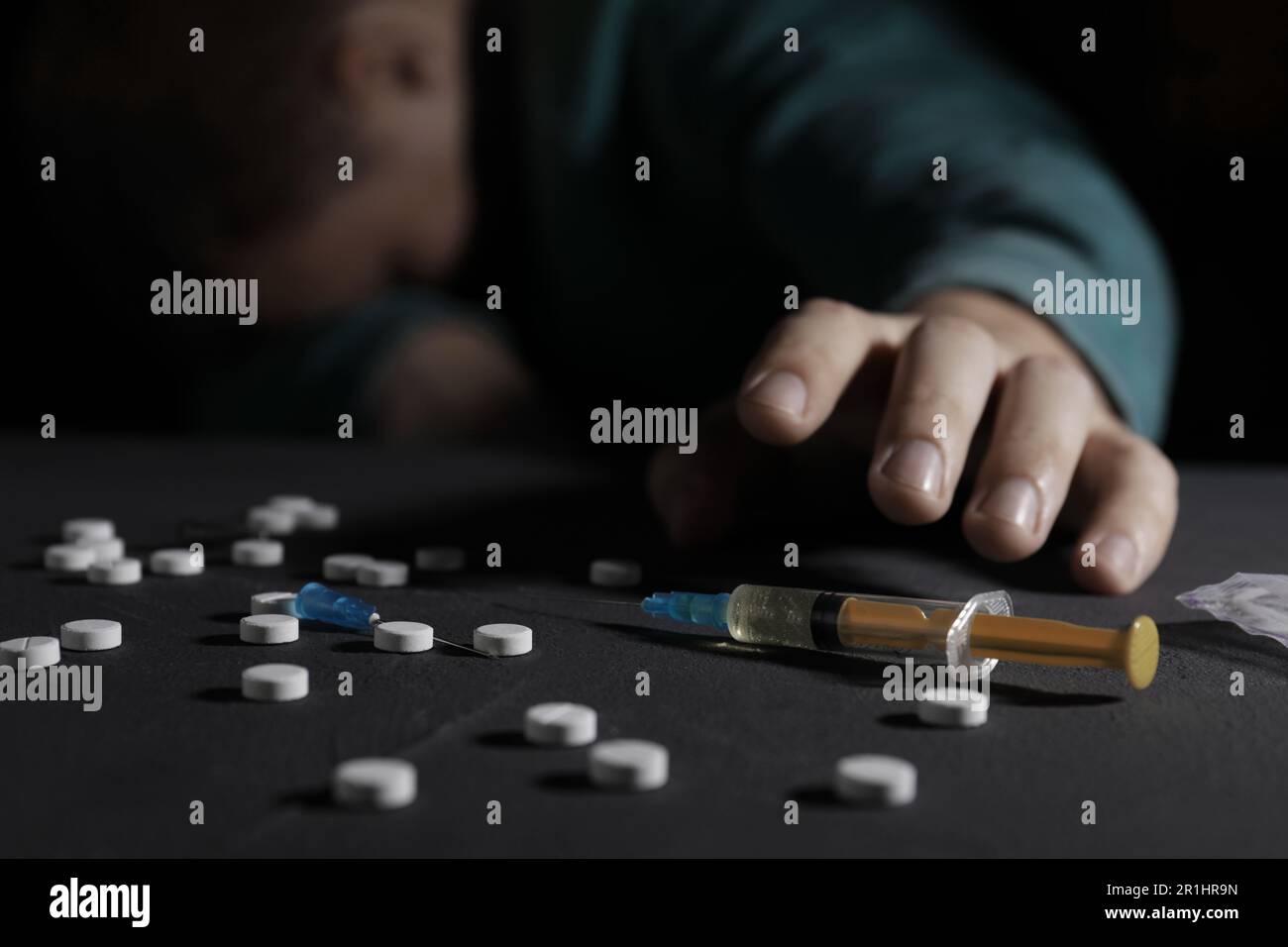Addicted man reaching to drugs at black table, focus on syringe Stock ...
