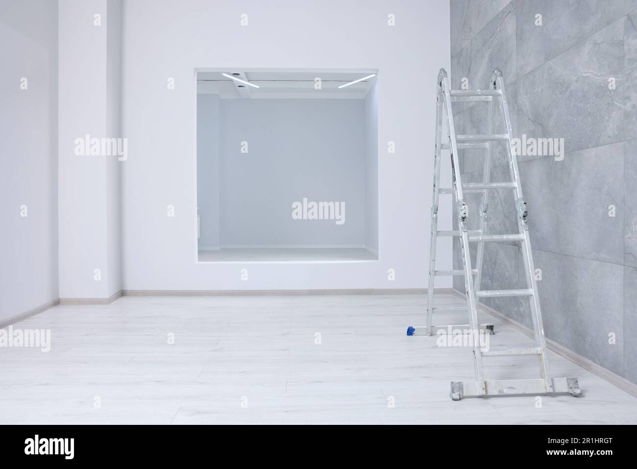 Empty room with tiled wall, ladder and opening for fake window during ...