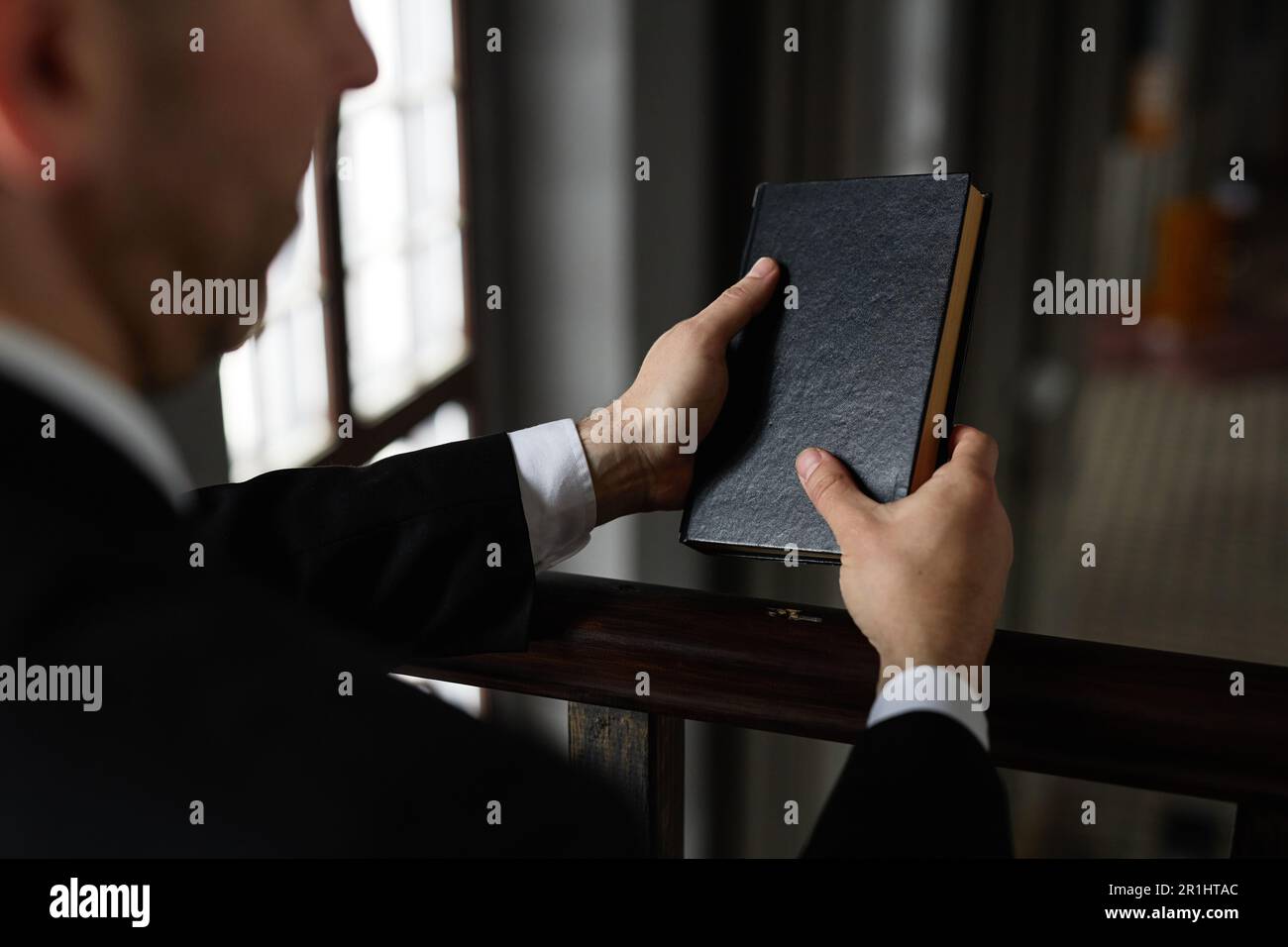 Close-up of priest reading Bible during praying standing in front of ...