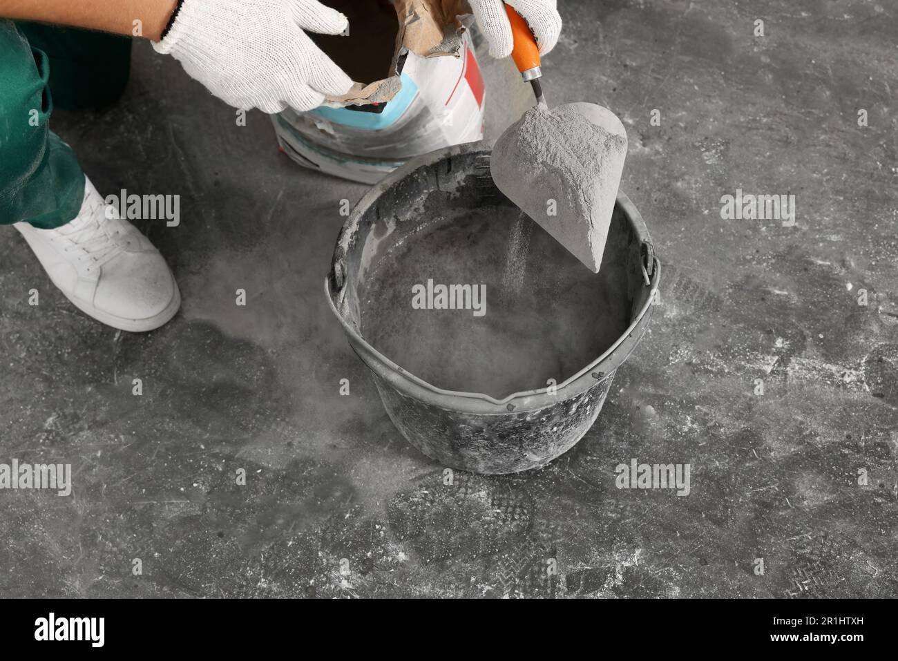 Person mixing cement in bucket hi-res stock photography and images - Alamy