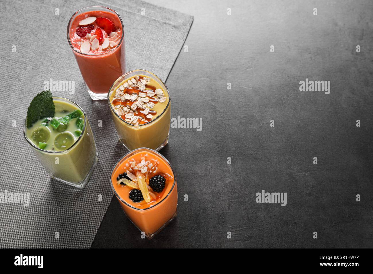 Many different delicious smoothies on grey table, above view. Space for ...