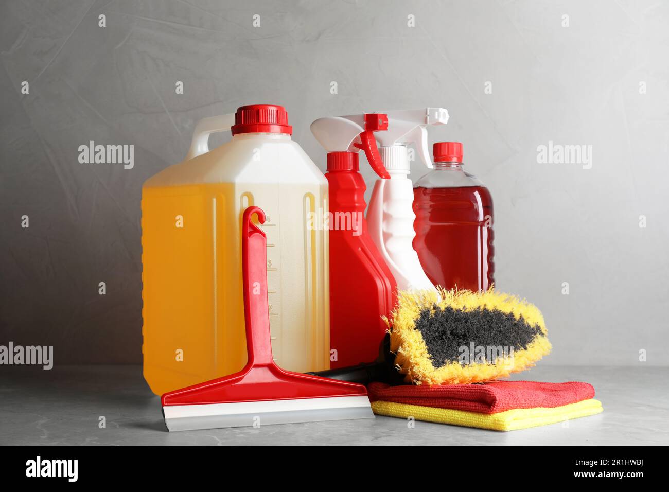 Car cleaning products and canister with motor oil on light grey table ...
