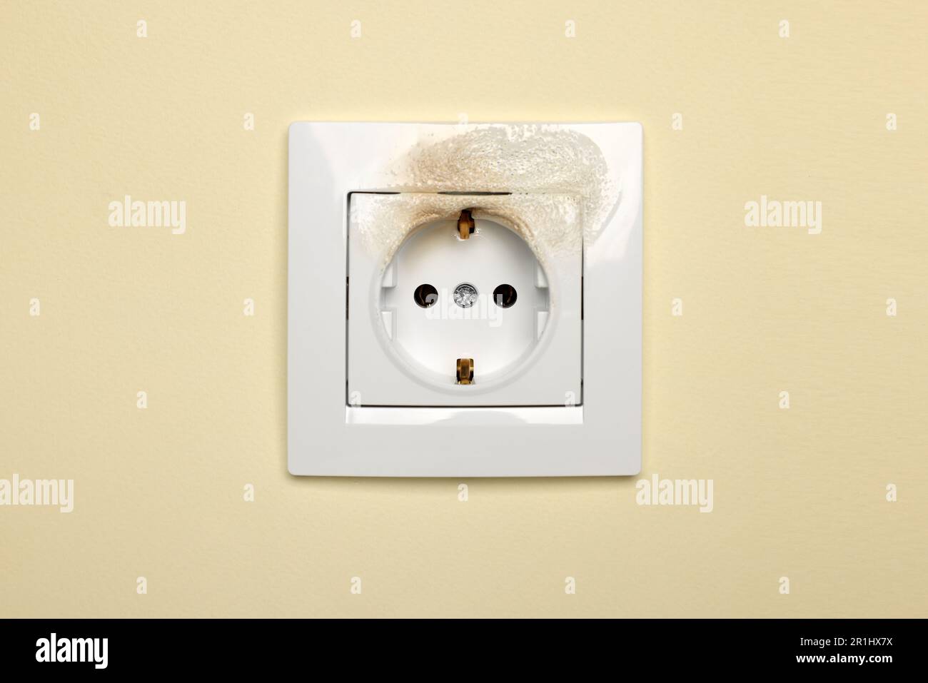 Burnt power socket on beige wall. Electrical short circuit Stock Photo ...