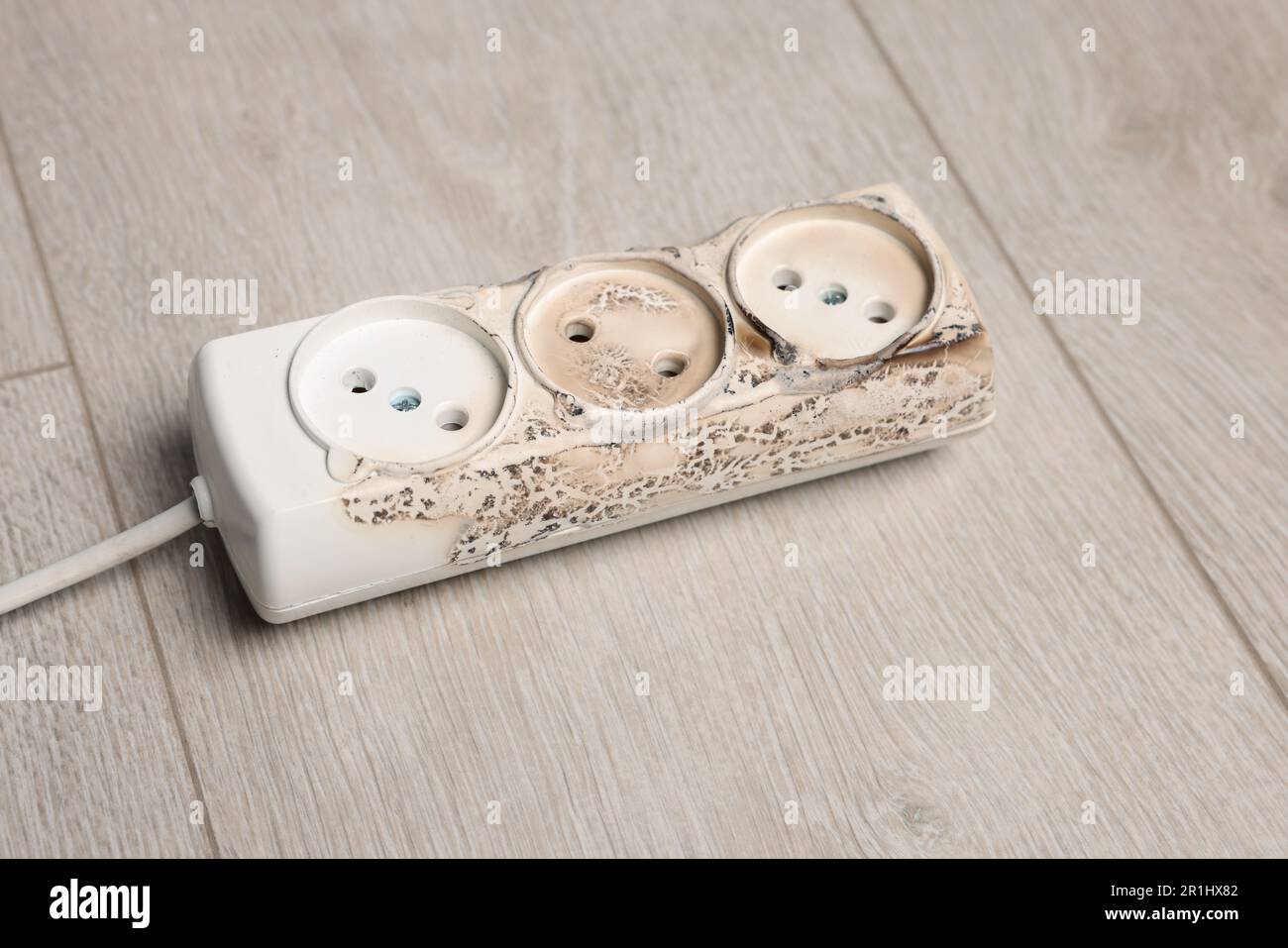 Burnt power strip on wooden floor. Electrical short circuit Stock Photo ...