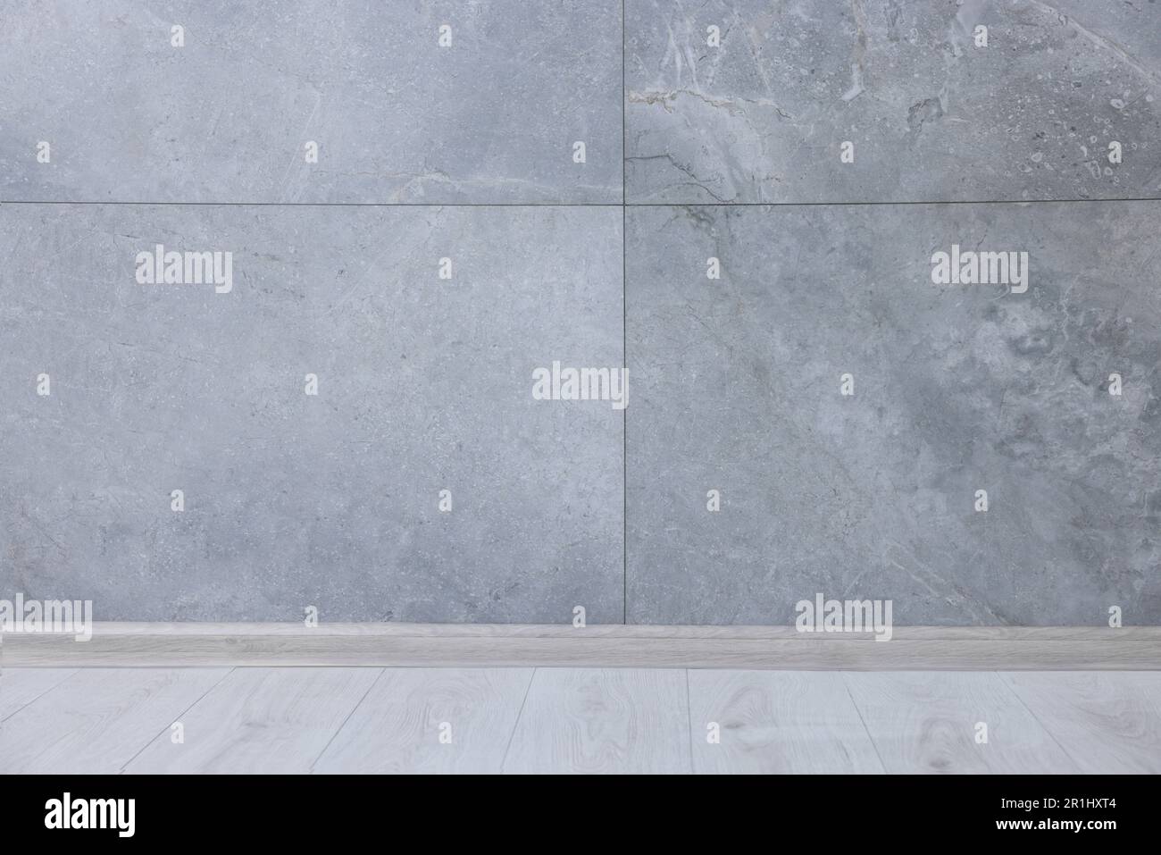 Beautiful light grey tiled wall and wooden floor in clean empty room ...