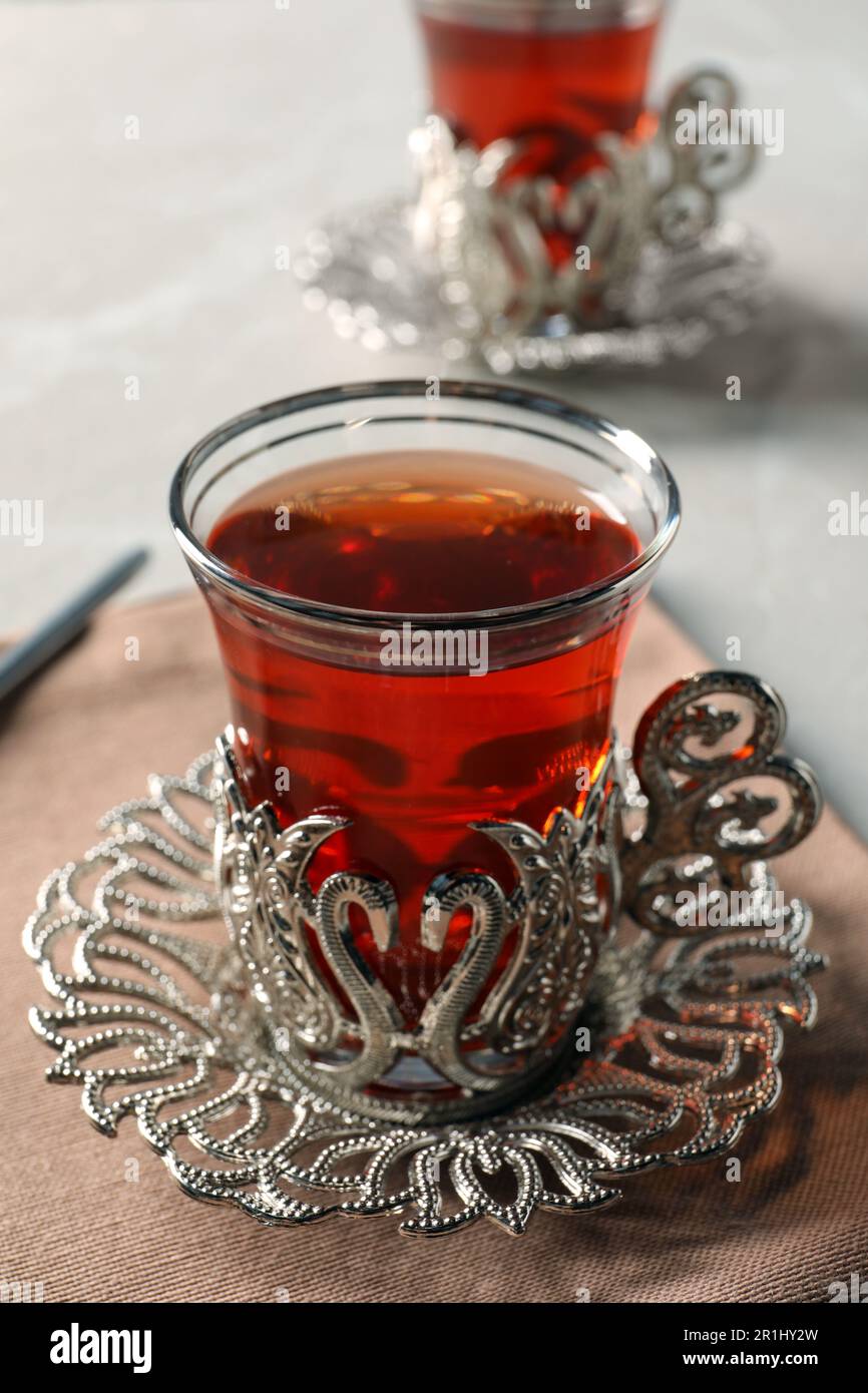 Glasses of traditional Turkish tea in vintage holders on table, closeup ...