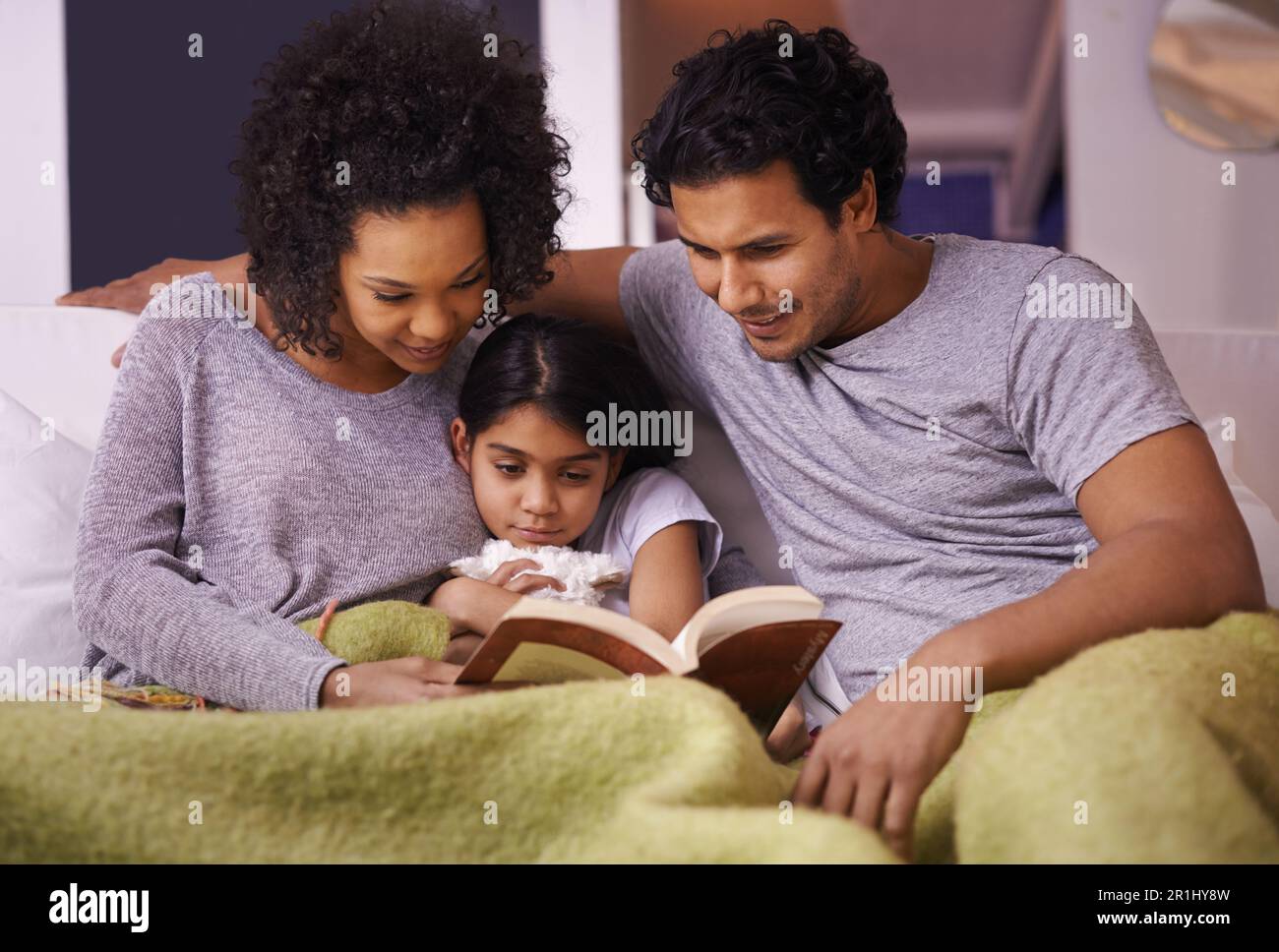 Family, child and reading a book together in a home for story time on a ...