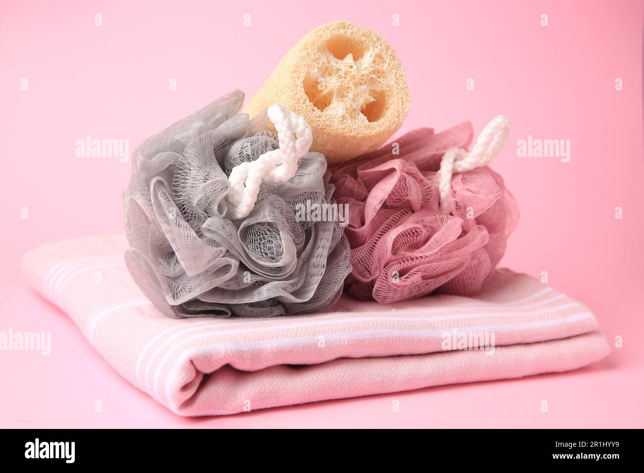 Colorful shower puffs, loofah sponge and towel on pink background Stock ...