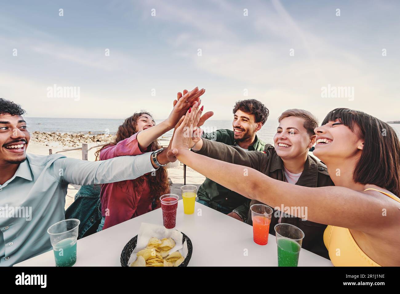 A diverse group of friends, including a non-binary person, celebrate ...