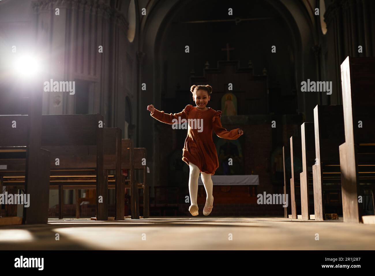 African American little girl playing and running in old church Stock ...