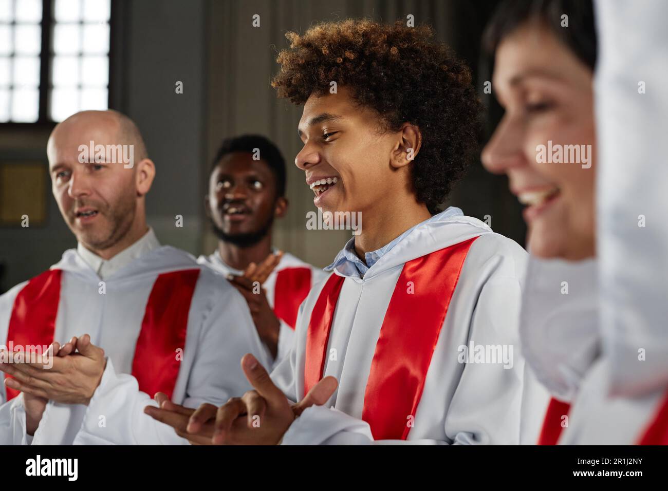 Group of happy people from church choir singing and clapping hands ...