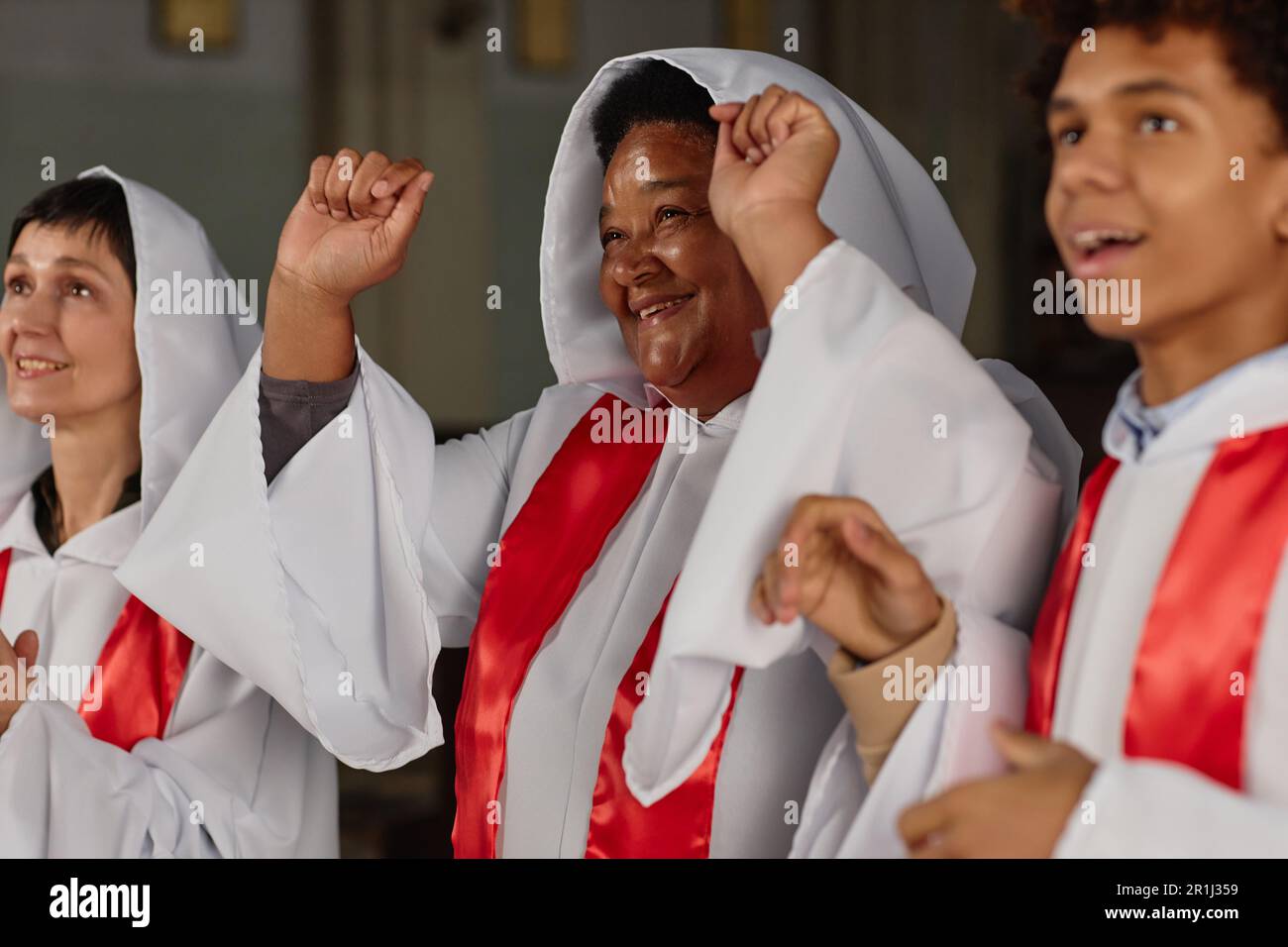 Group of happy people in white costumes singing together in church ...