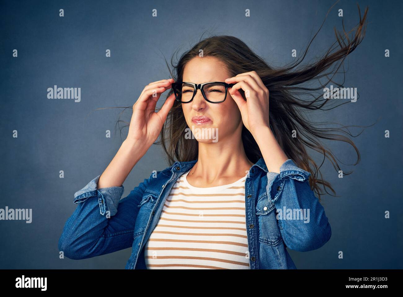 Can someone turn off that fan. a happy young woman with air being blown ...