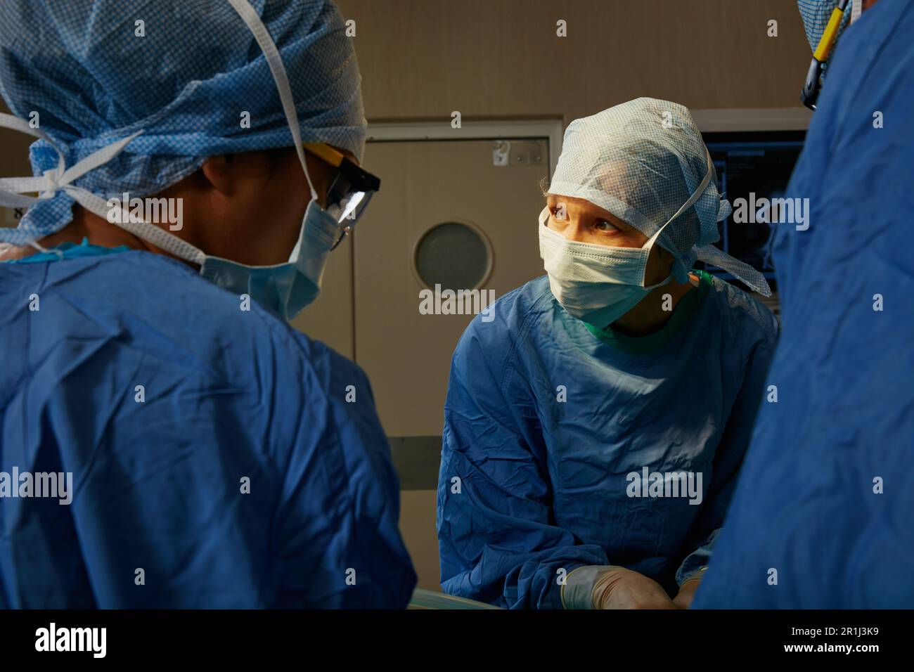 Shes leading the operation. a team of surgeons performing a surgery in ...