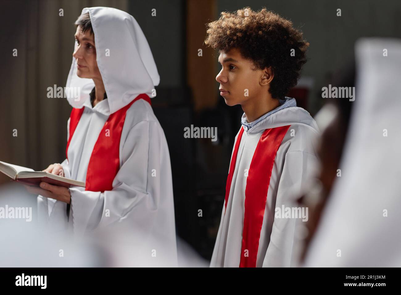 Group of people from church choir reading prayer while standing in ...