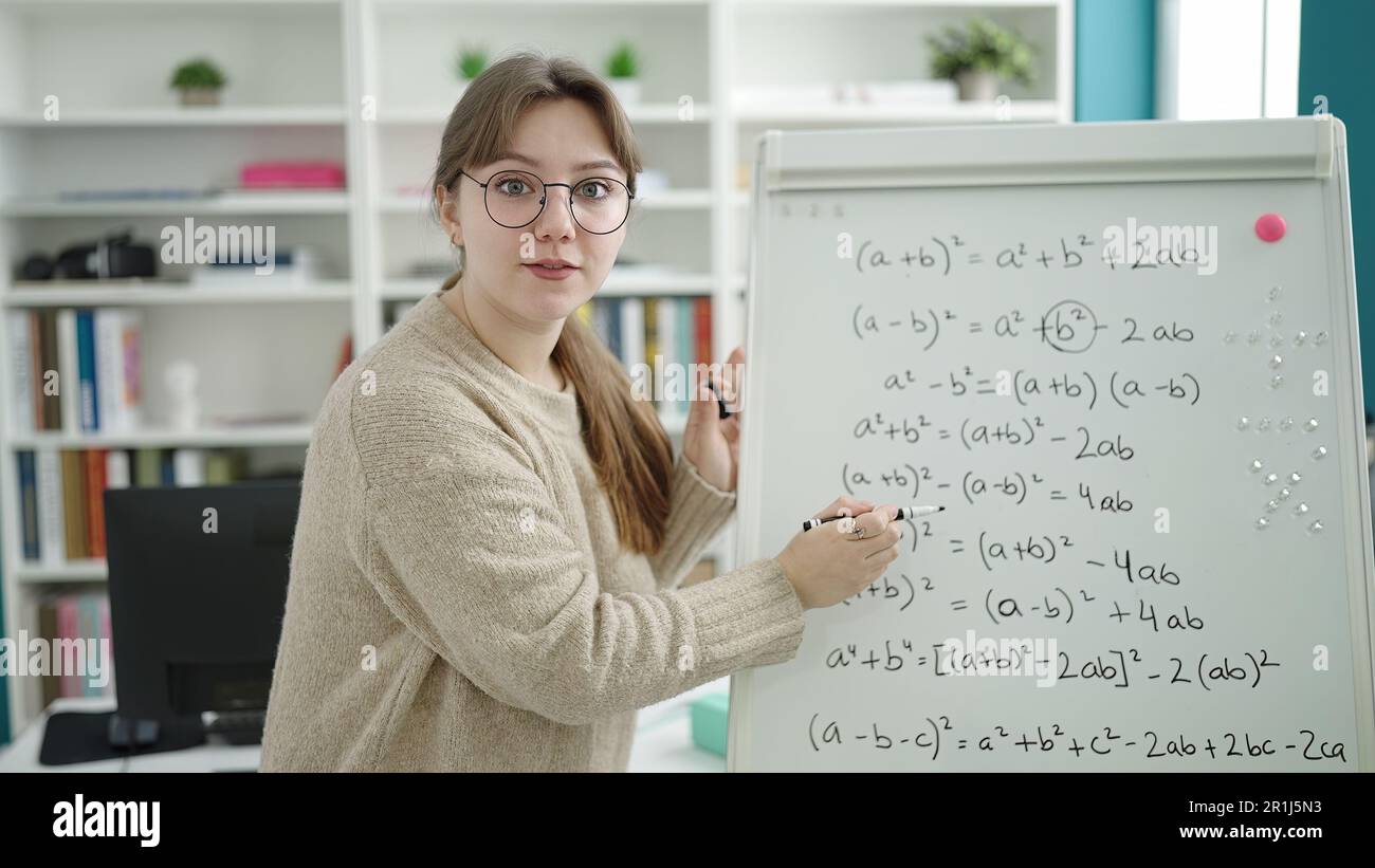 Young blonde woman teacher explaining maths lesson at library ...