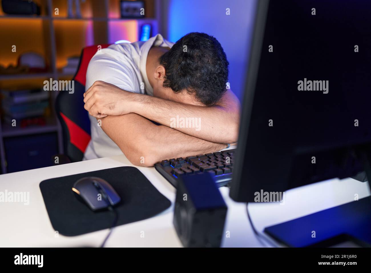 Young hispanic man streamer stressed using computer at gaming room ...