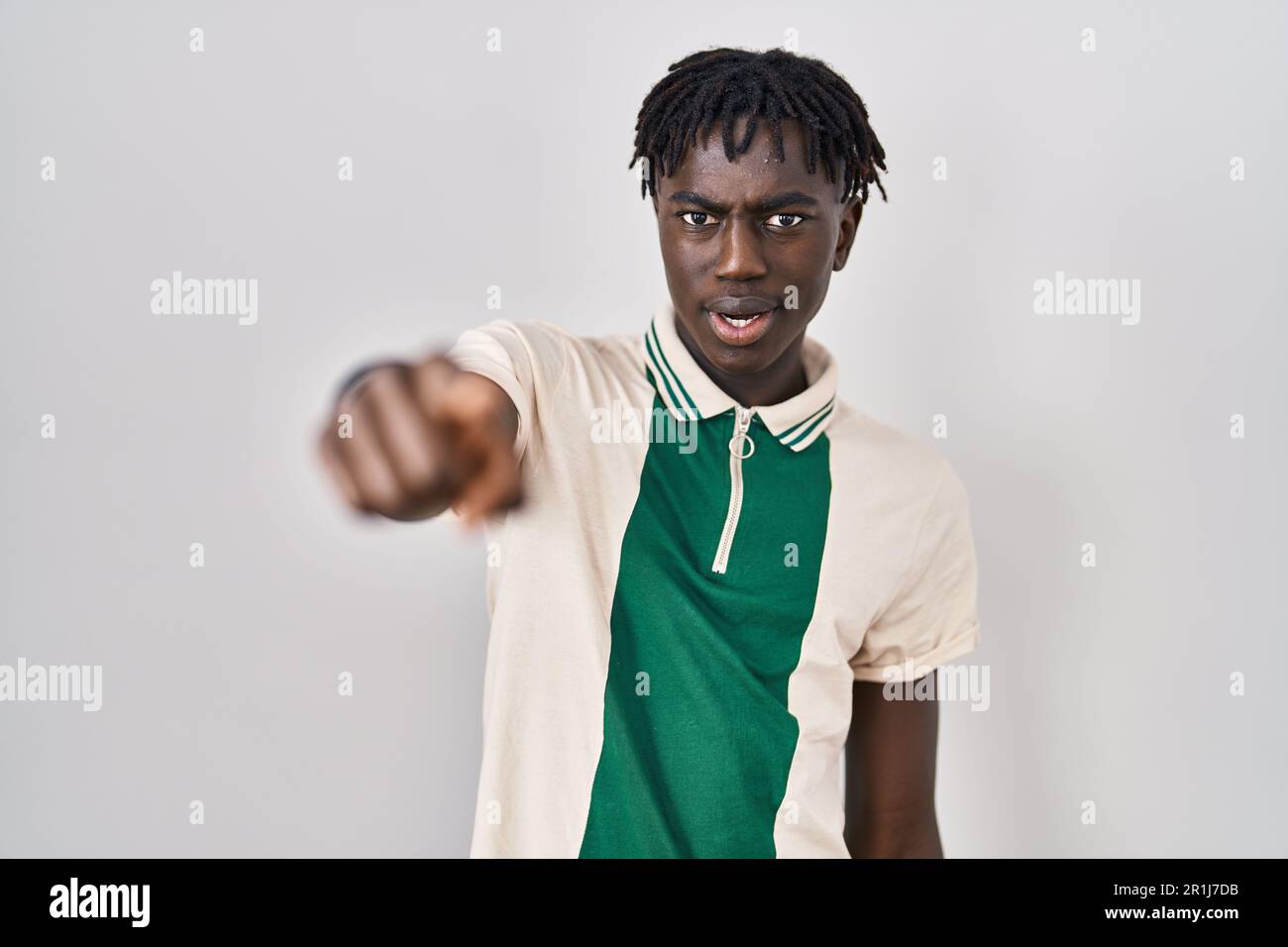 African man with dreadlocks standing over isolated background pointing ...