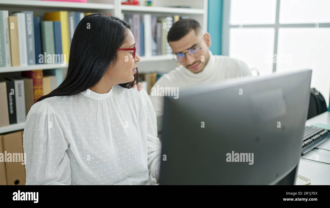 Man and woman students using computer studying at university classroom ...